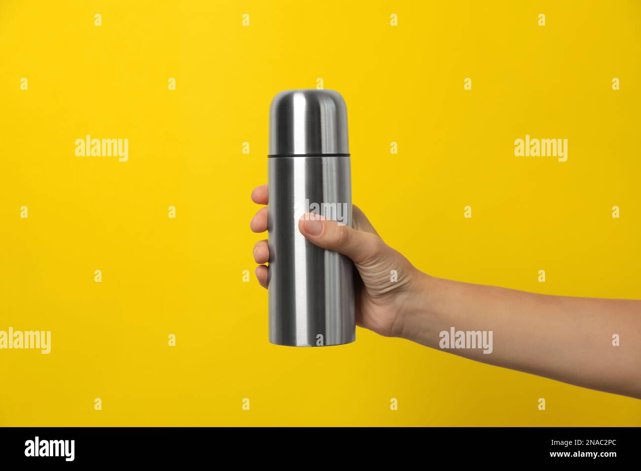 Woman holding modern thermos on yellow background, closeup Stock Photo ...