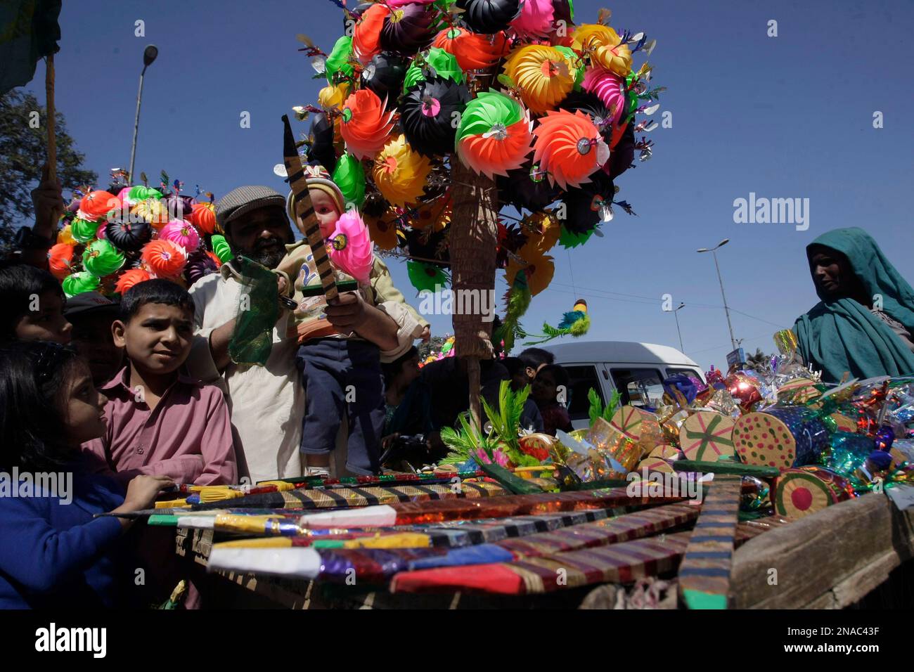 A Pakistani buys replica of sword and toys to his children from a stall ...