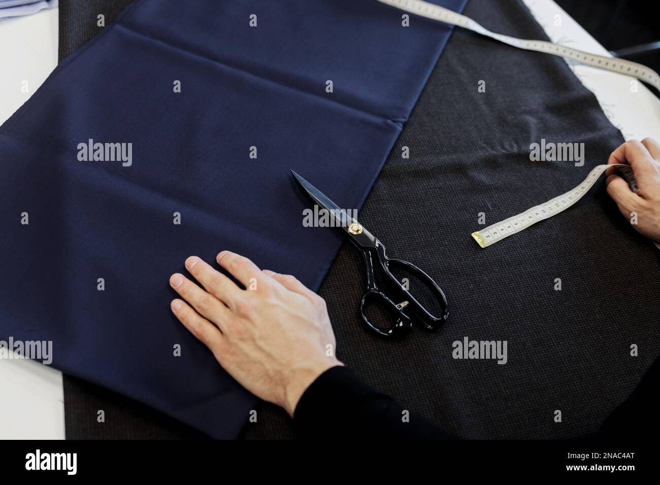 tailor working near table. tailoring and repair of clothes. workshop ...