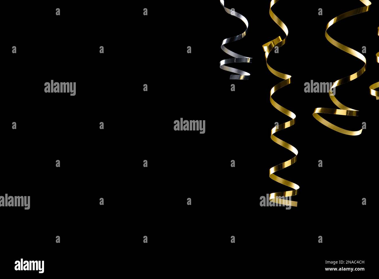 Shiny serpentine streamers on black background. Space for text Stock ...