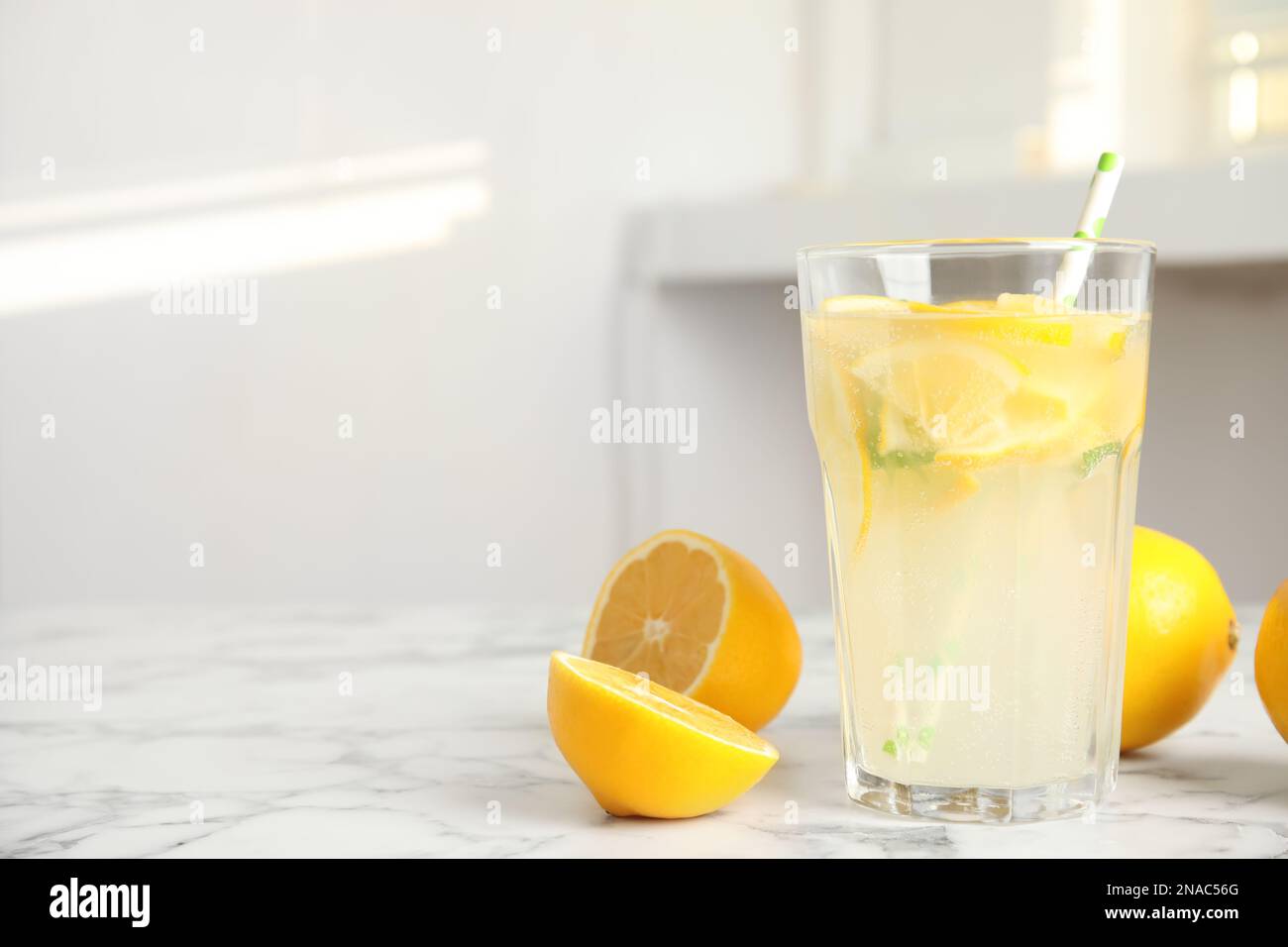 Cool freshly made lemonade and fruits on white marble table. space for ...