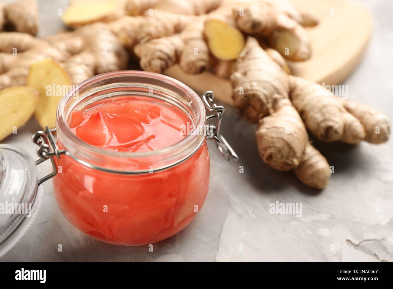 Spicy pickled ginger and root on light grey table, space for text Stock ...