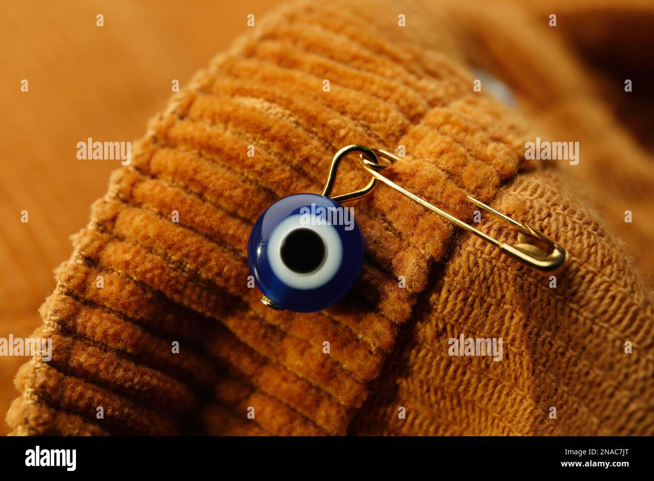 Evil eye safety pin on clothing, closeup Stock Photo - Alamy