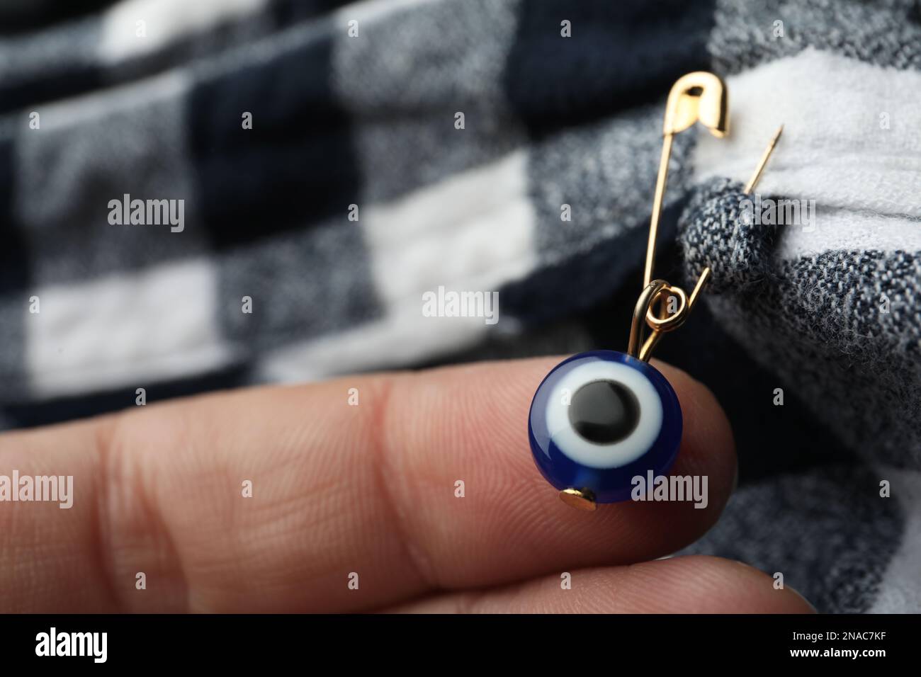 Woman pinning evil eye amulet on clothing, closeup Stock Photo - Alamy