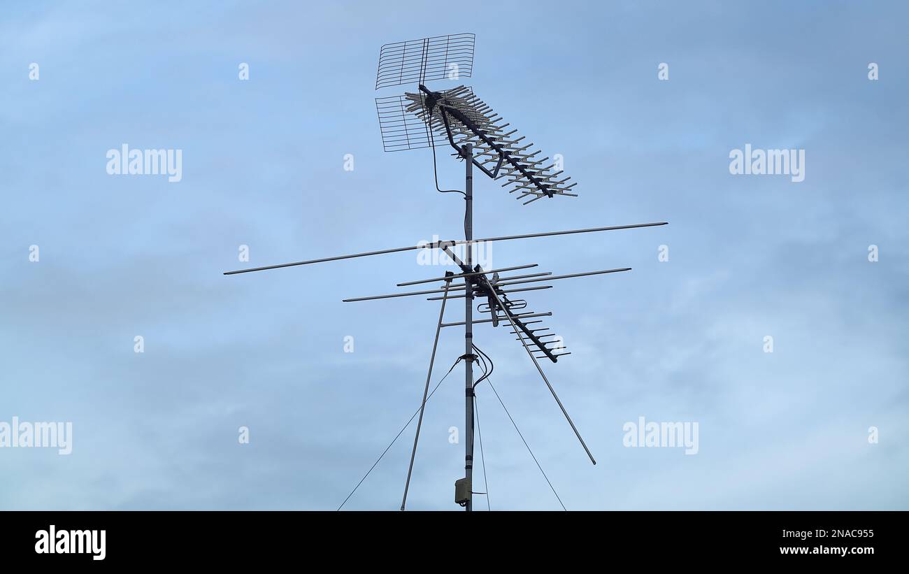 The Multiple antennas standing on top of the rooftop against the blue ...