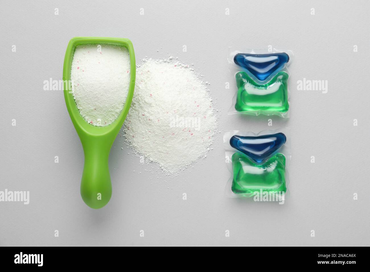 Laundry capsules and detergent powder on light grey background, flat ...