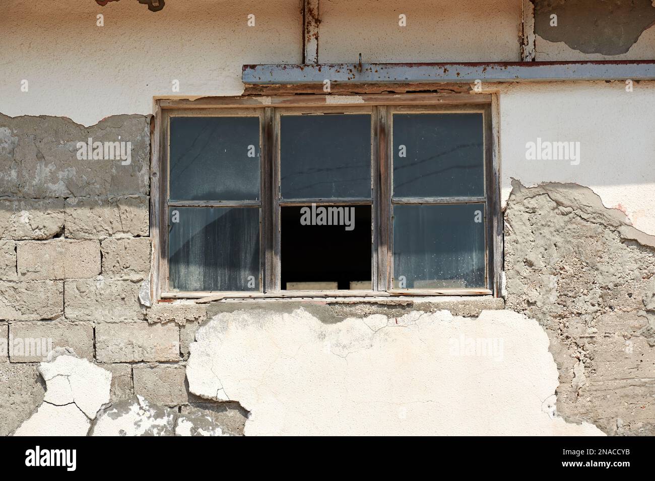 Broken and crashed window on the damaged building facade. War and ...