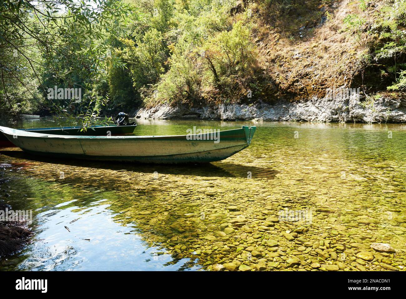 Traditional wooden boats on the coast of the shallow river. Simple ...