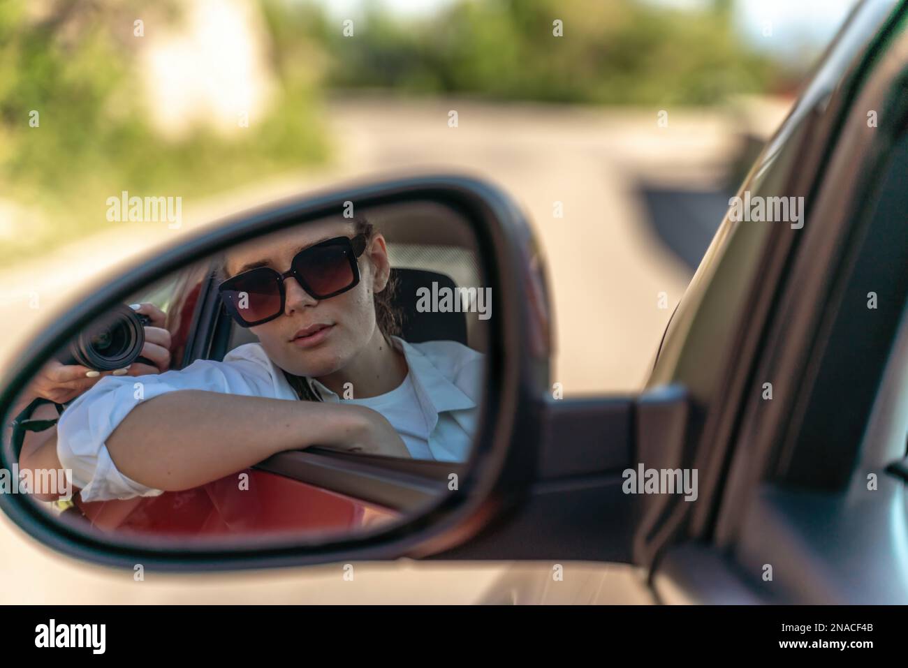 Woman car mirror. Portrait of a beautiful woman in a new car looking in ...