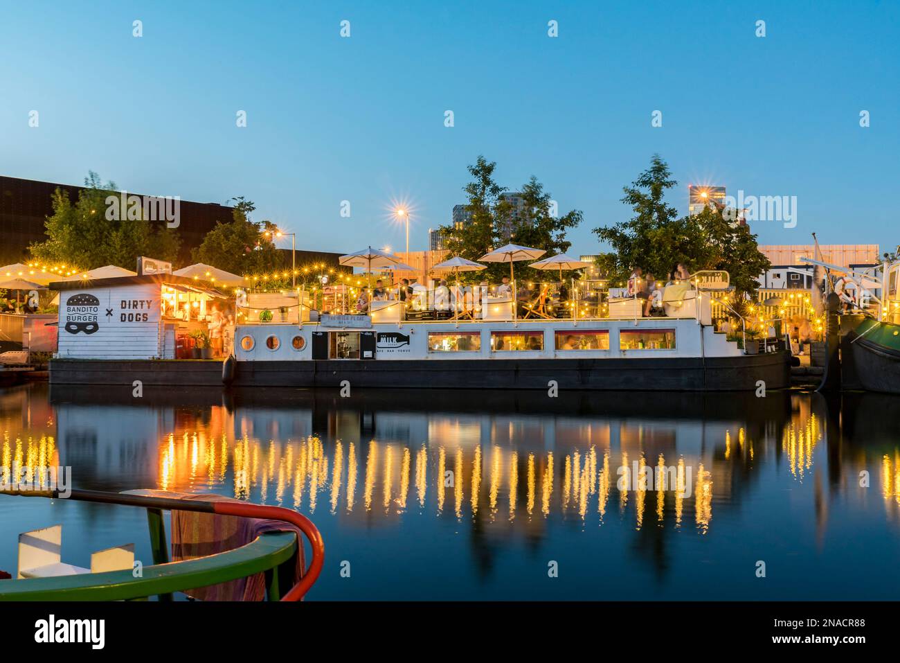 People enjoying the sunset in a narrow boat bar in Hackney Wick, London ...