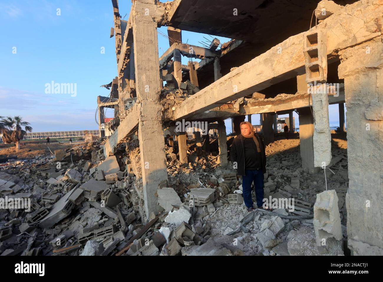 A Palestinian man inspects a destroyed wedding hall after being ...