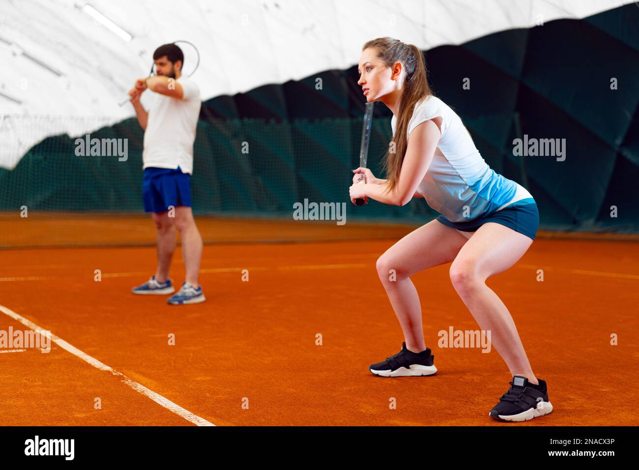 Pair of tennis players, man and woman waiting for service at indoor ...