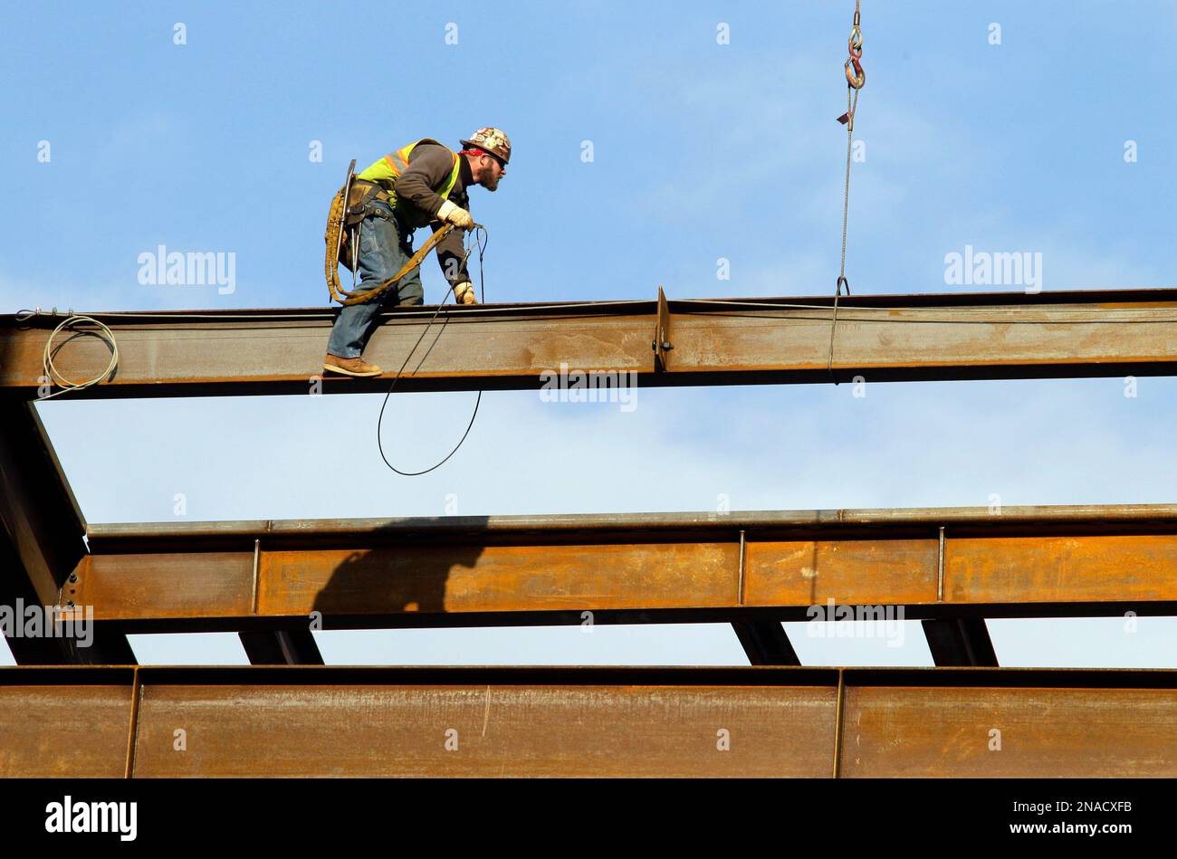 An ironworker crosses a steel beam seven stories up on the Medical Mart ...