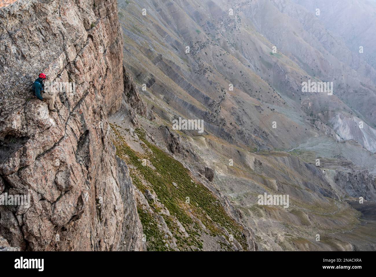 A National Geographic writer sits on a cliff's edge during trek toward Dark Star, a limestone ...