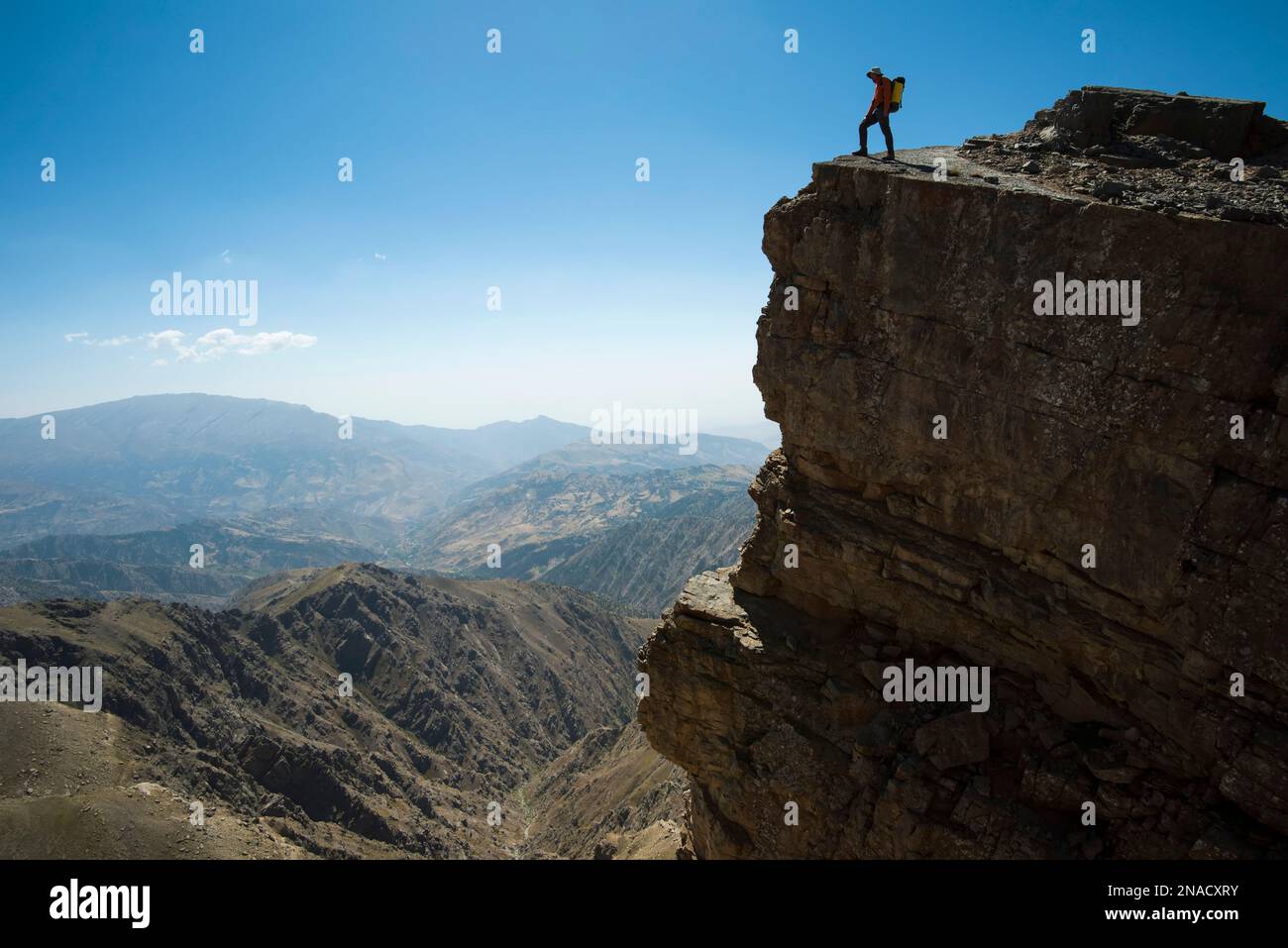 An expedition team members stand on a cliff's edge during trek toward Dark Star, a limestone ...