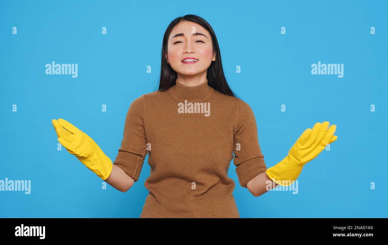 Happy asian maid being happy about finishing house cleaning while ...