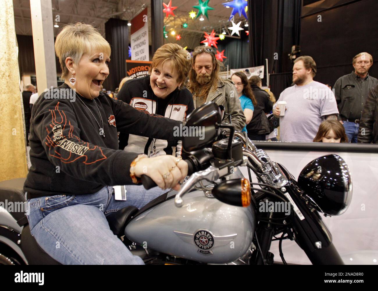 Cim Tupps, left, from Mansfield, Ohio reacts as she fires up a Harley ...