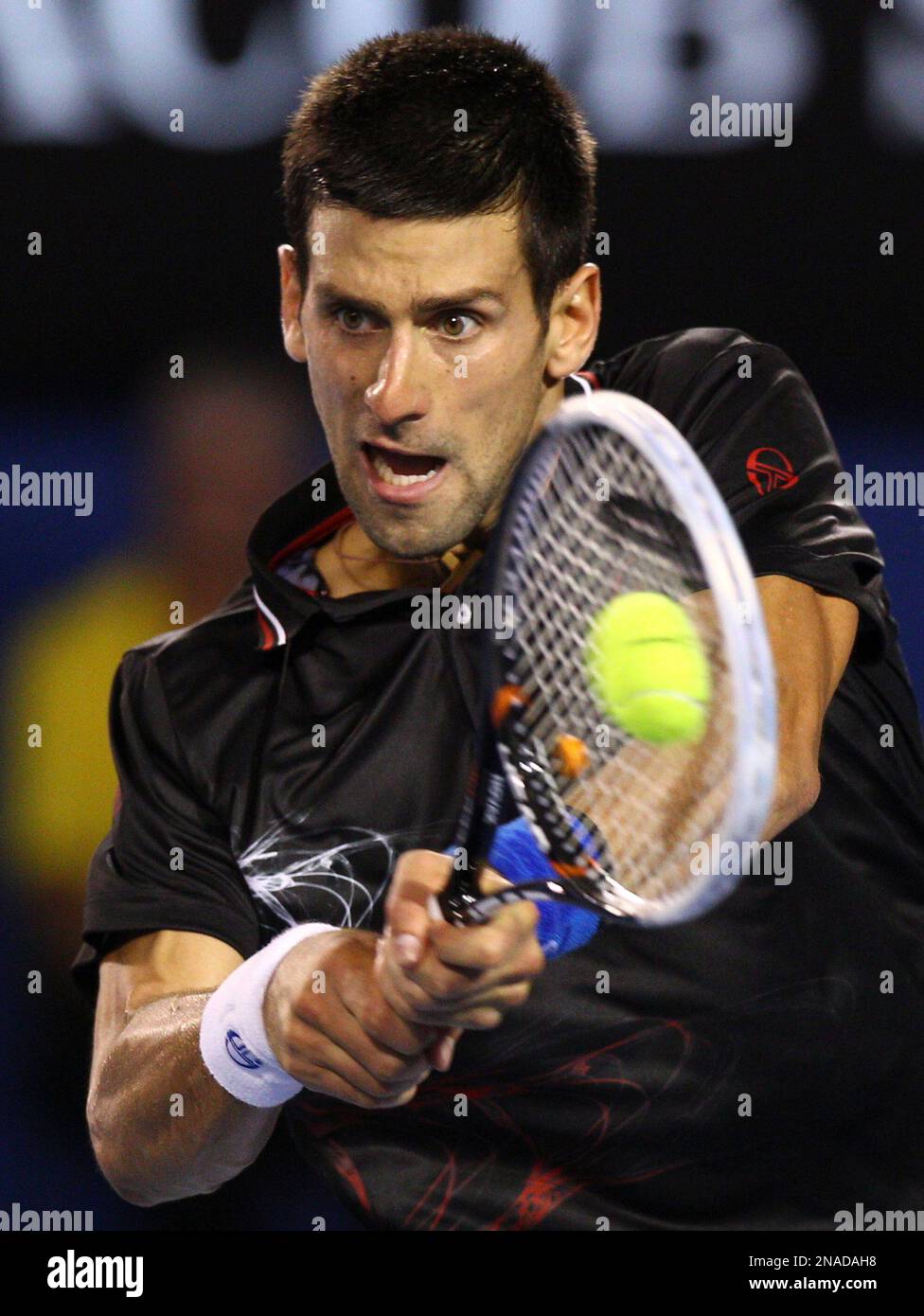 Novak Djokovic of Serbia hits a backhand return to Rafael Nadal of ...