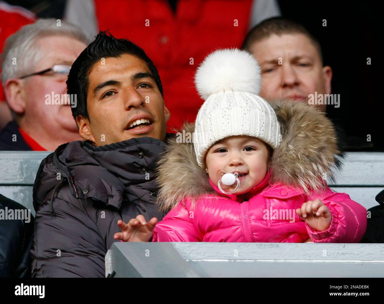 Liverpool's Luis Suarez holds his daughter Delfina prior to watching ...