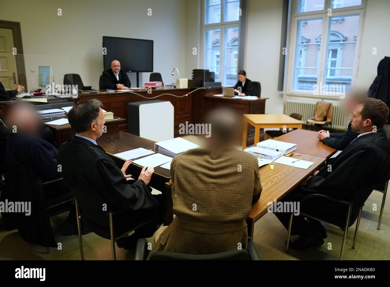 13 February 2023, Hamburg: The defendants (l, M, and rear r) sit with ...
