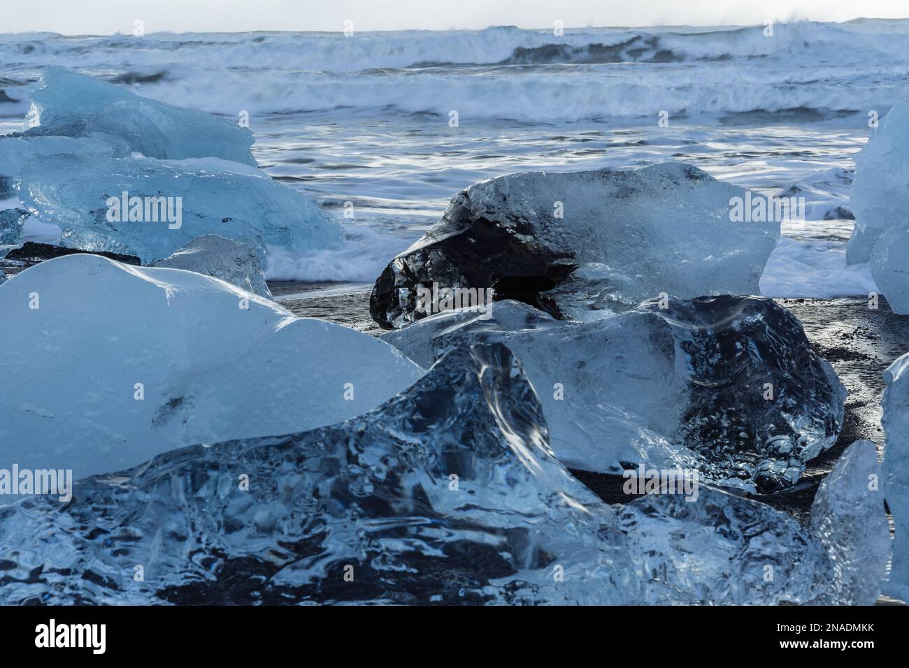 A pile of freshly melted ice cubes sits on a serene beach landscape ...