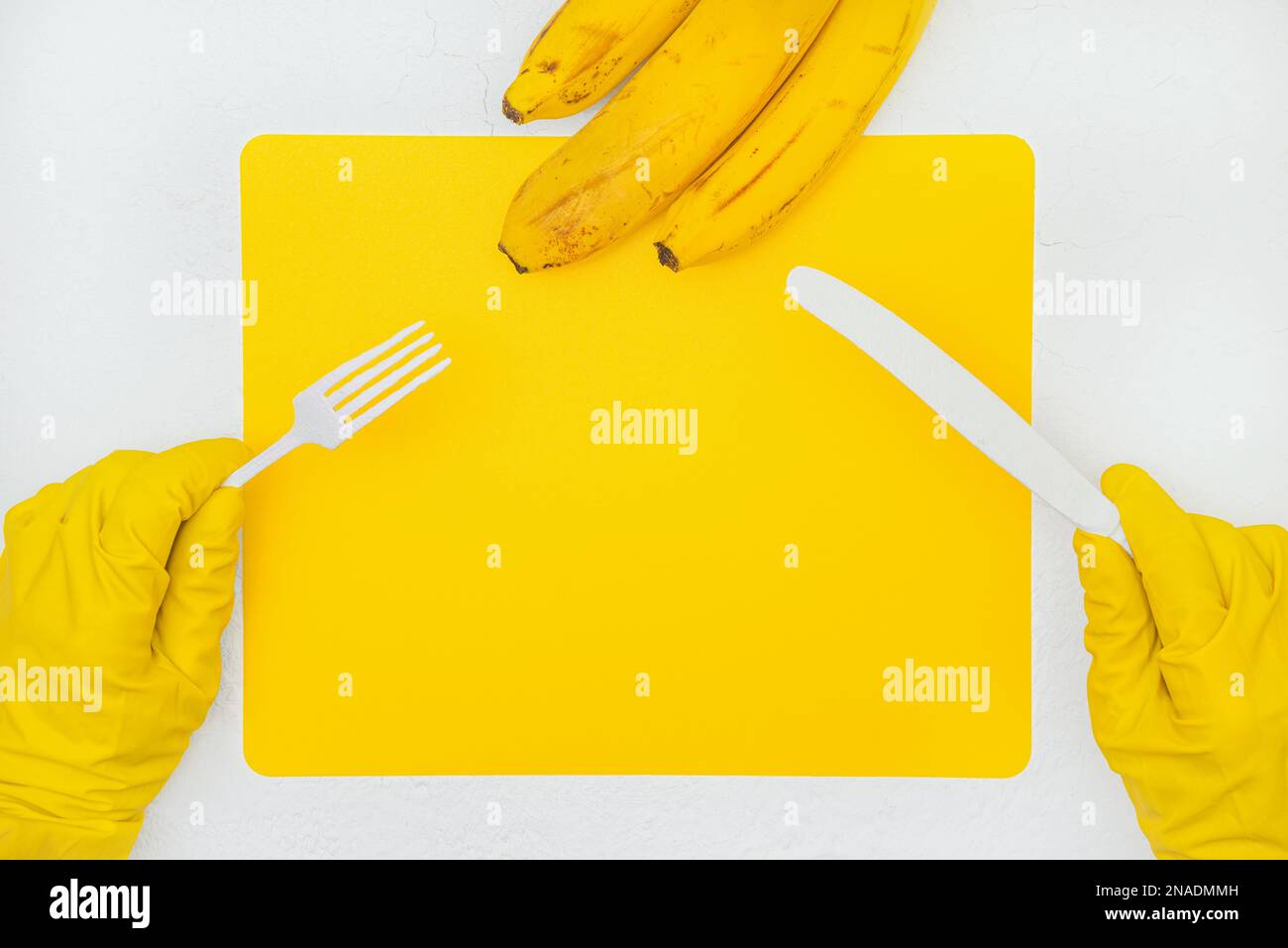 Human eats his lunch. At the table is a white plate, knife, fork ...