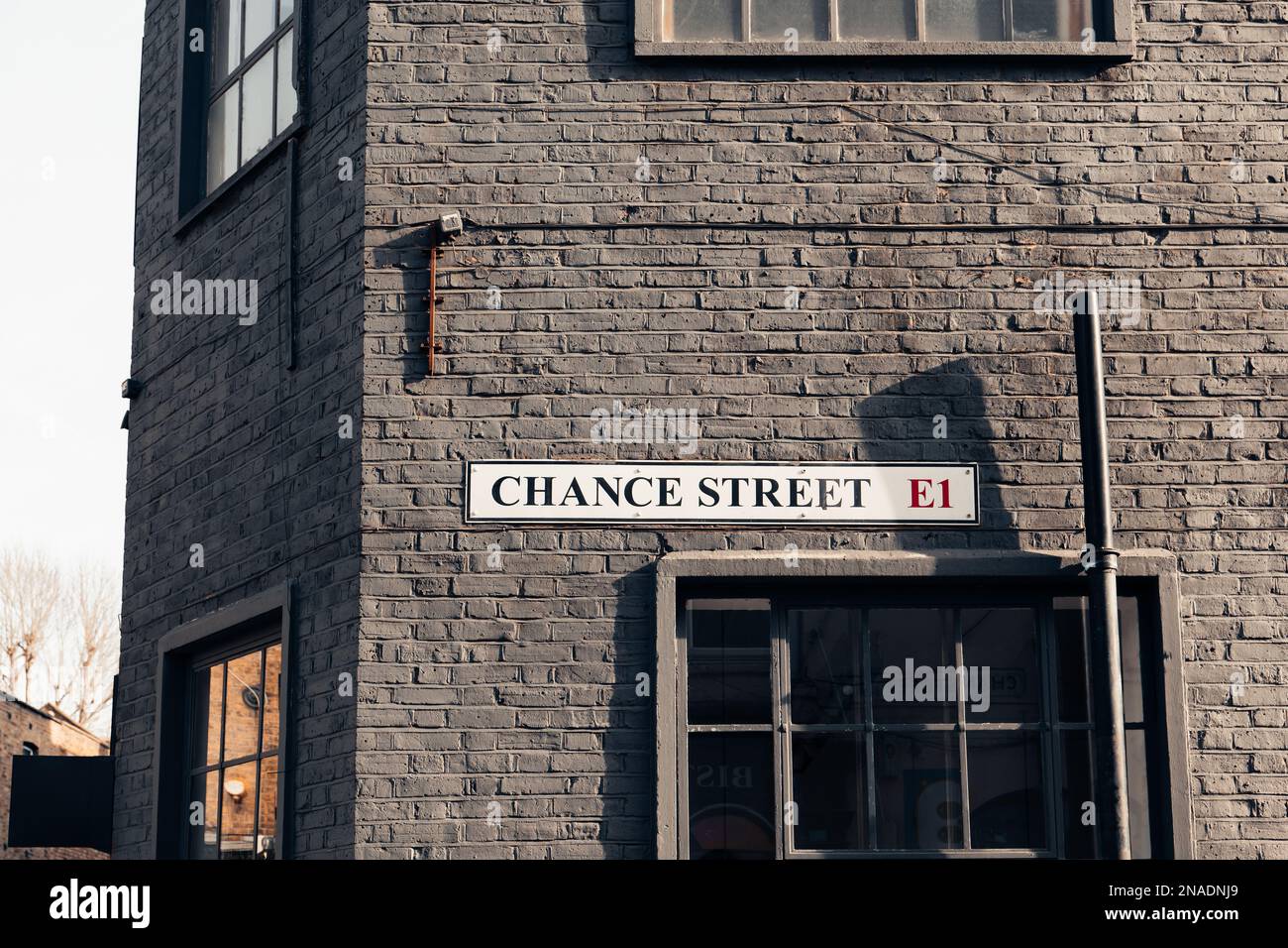 Street name sign on a wall of a black brick building on Chance Street ...