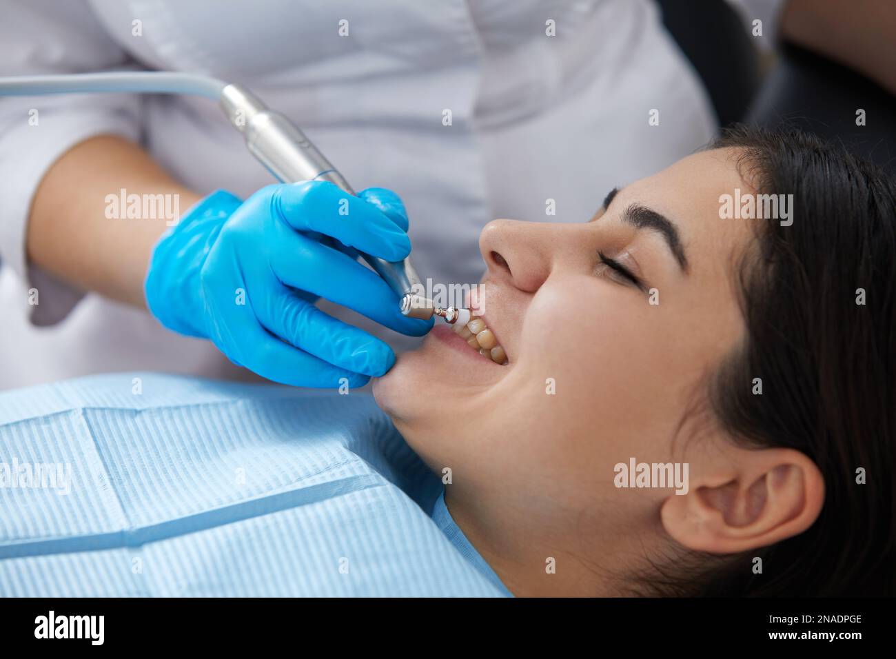 Young woman getting her teeth polished in dental clinic. Professional ...