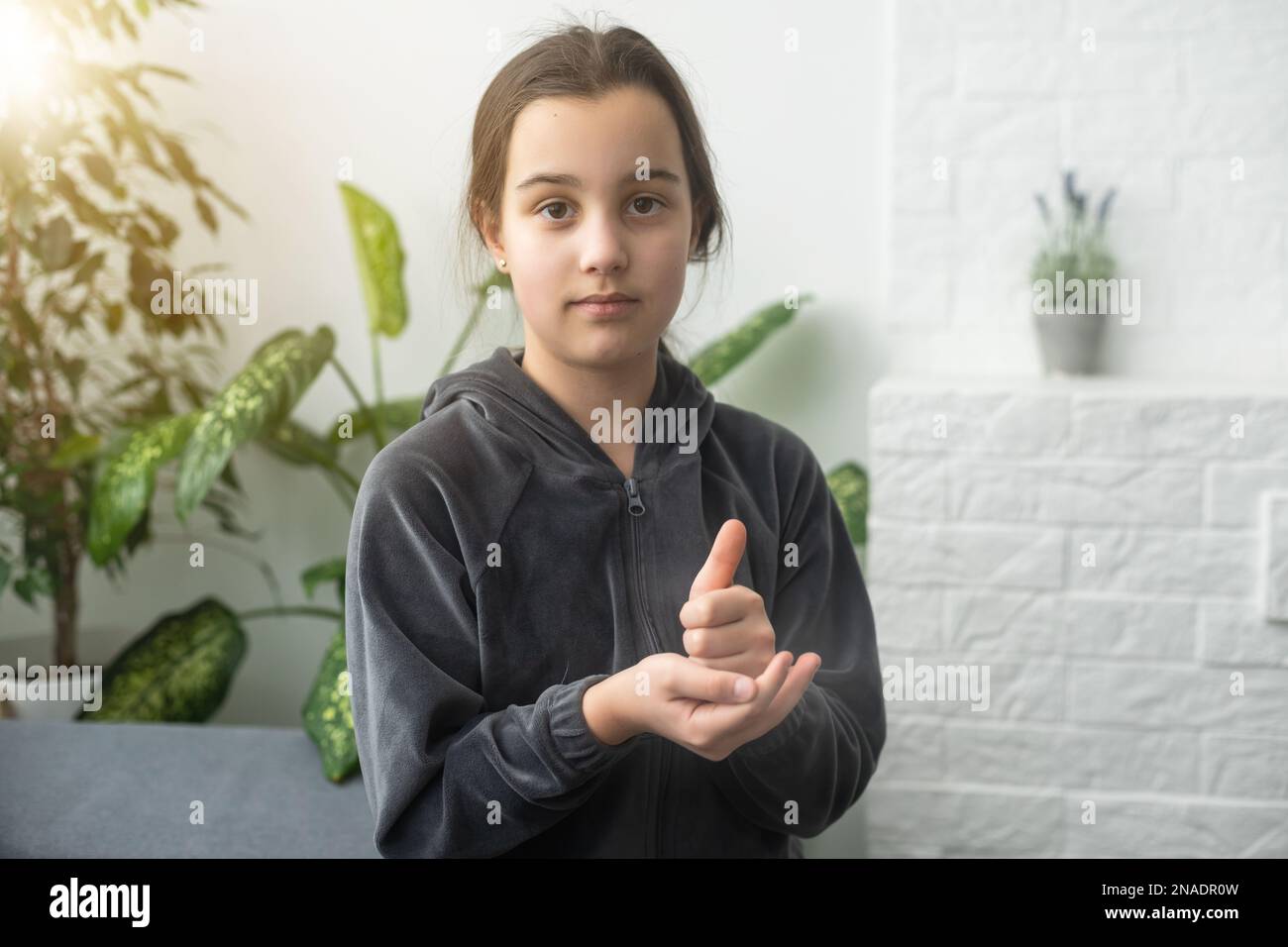Cute deaf mute girl using sign language on light background Stock Photo ...