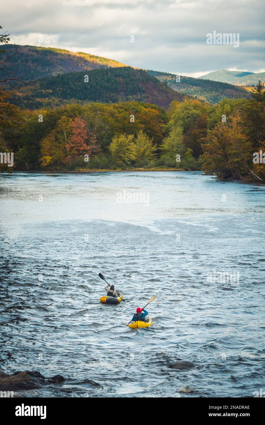 Two paddlers going down river with fall foliage Stock Photo - Alamy