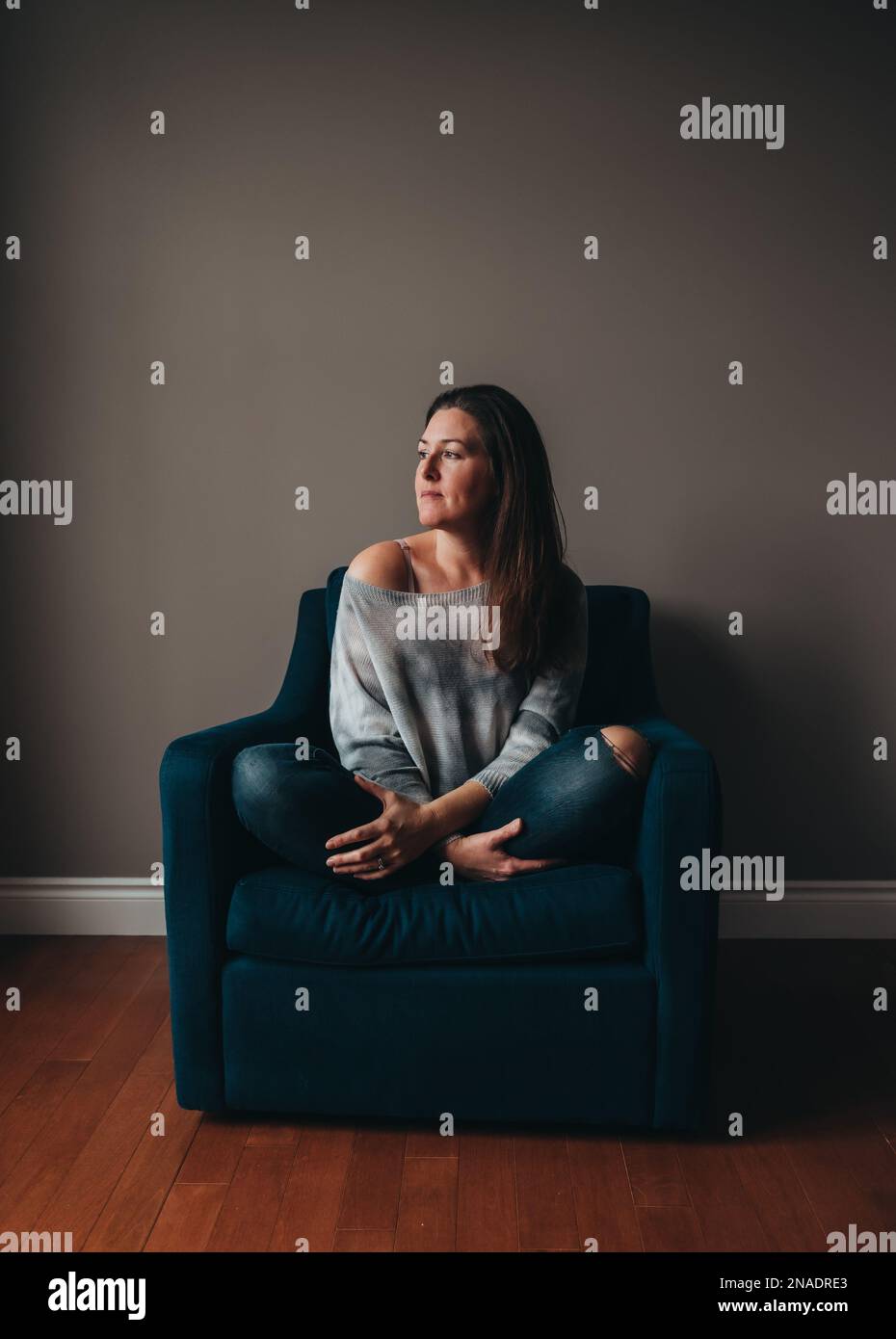 Attractive woman sitting in a comfortable chair in an empty room Stock ...