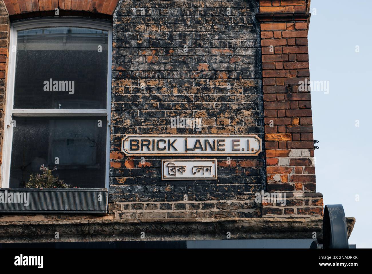 English and Bengali bilingual street name sign on a building in Brick ...