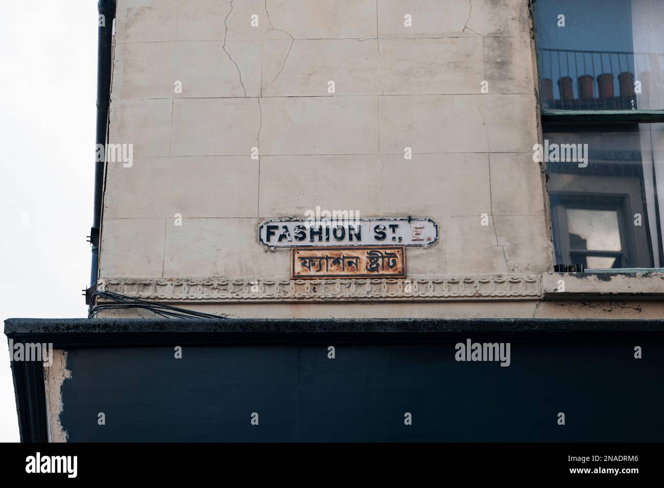 English and Bengali bilingual street name sign on a building on Fashion ...