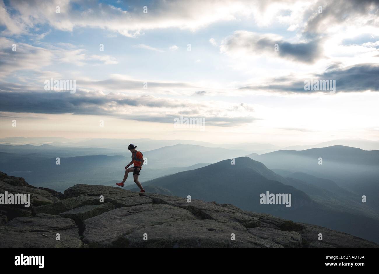 Trail runner man walking along ridge with mountains Stock Photo - Alamy