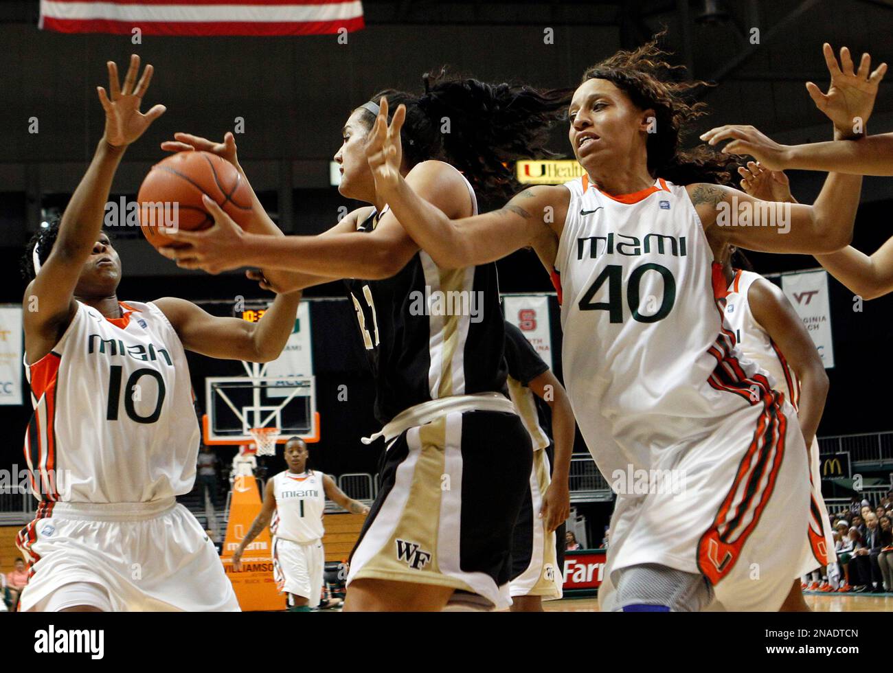 Wake Forest's Sandra Garcia (21) grabs a rebound over Miami's Michelle ...