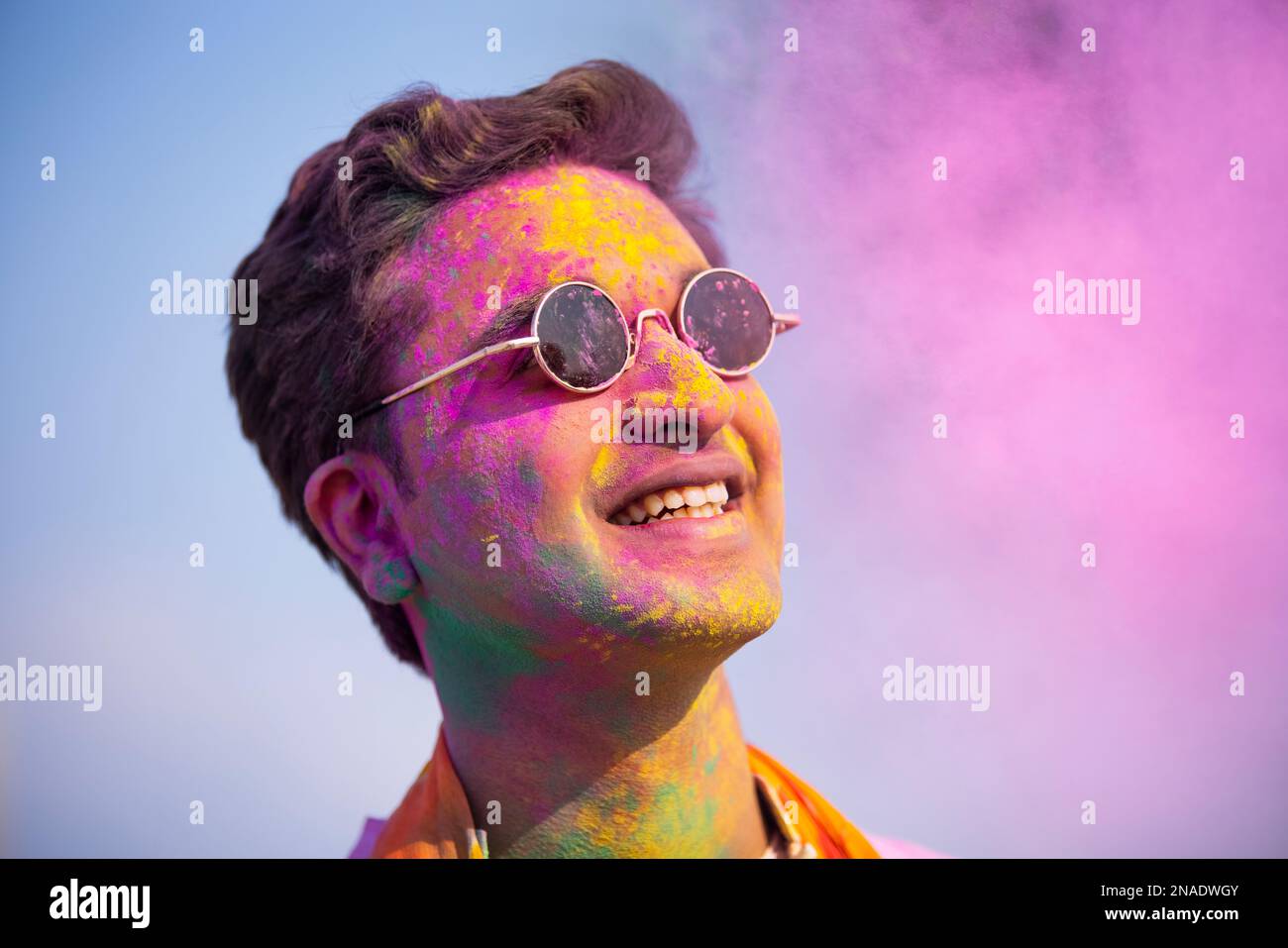a young man with colour on his face is happily posing in front of ...