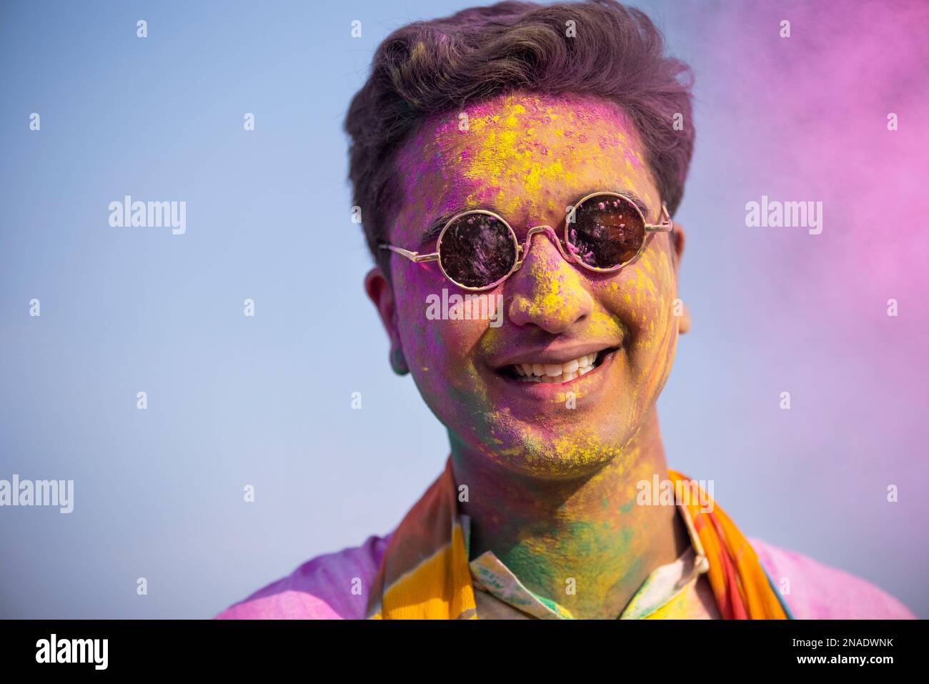 a young man with colour on his face is happily posing in front of ...