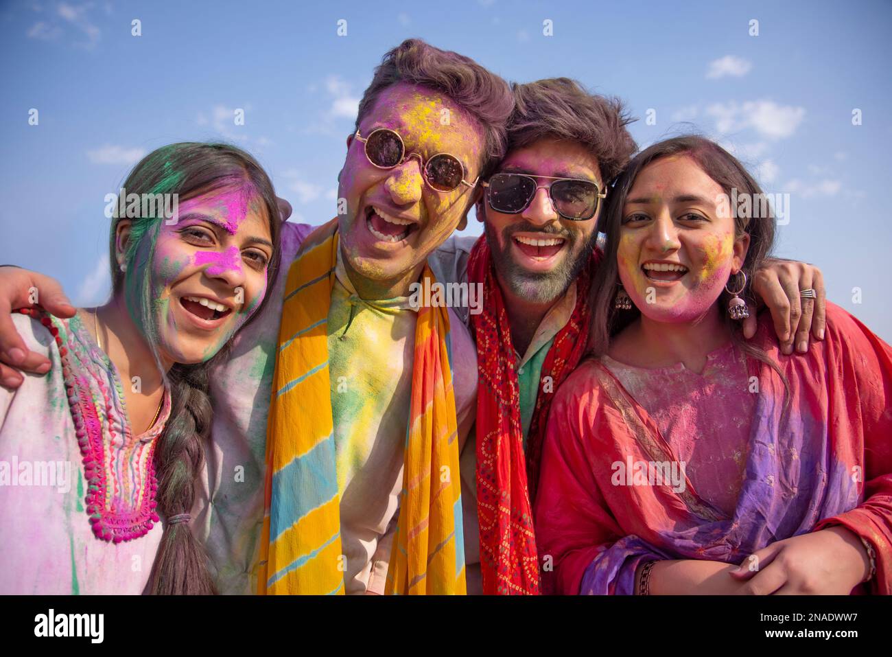 a group of young friends posing together happily during holi ...