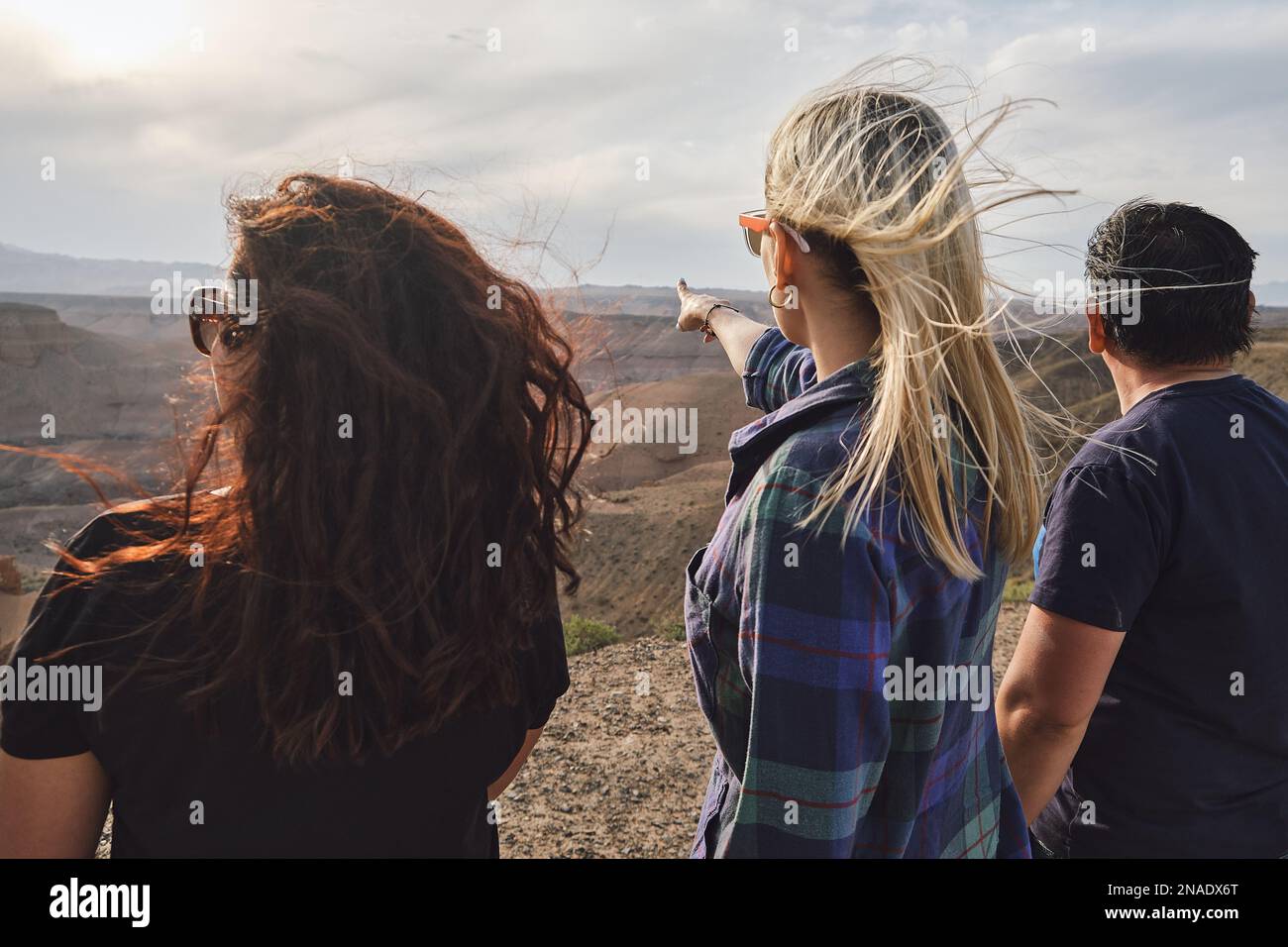 Three people looking to the Grand Canyon from a viewpoint, windy Stock ...