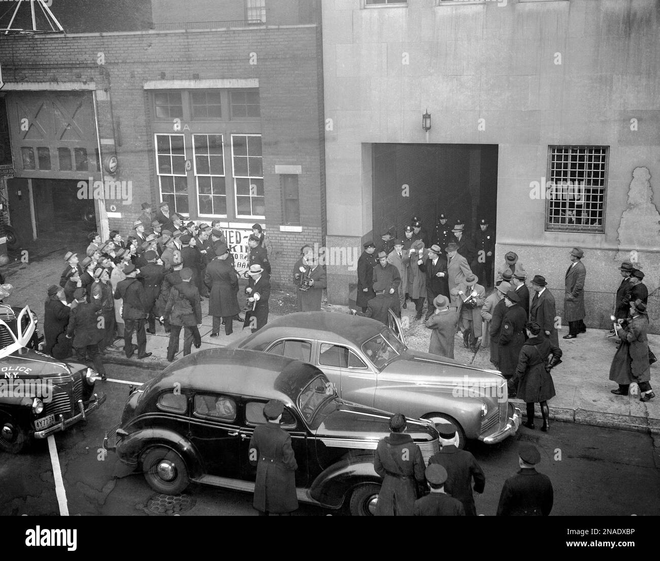 Mrs. Emanuel Weiss and Betty Lepke peer through a crowd outside ...