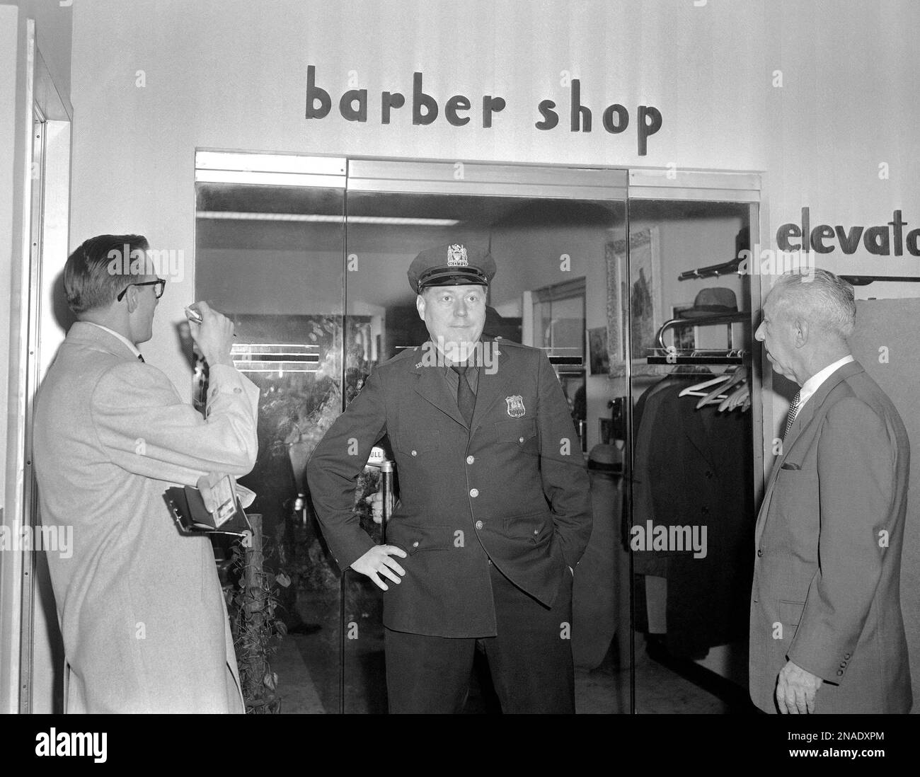 A policeman guards the entrance to barber shop in the midtown New York ...