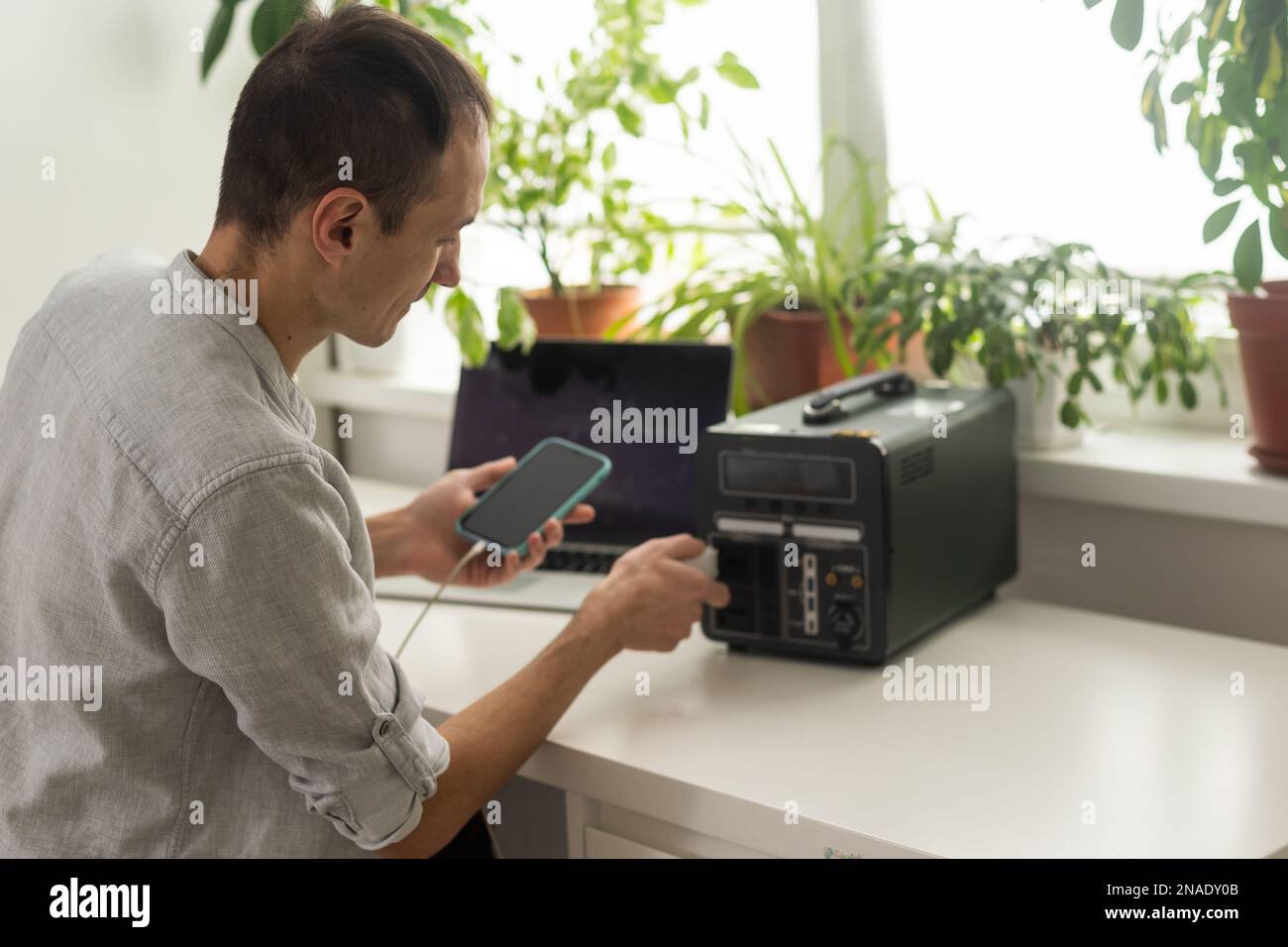 a man uses a portable charging station Stock Photo - Alamy