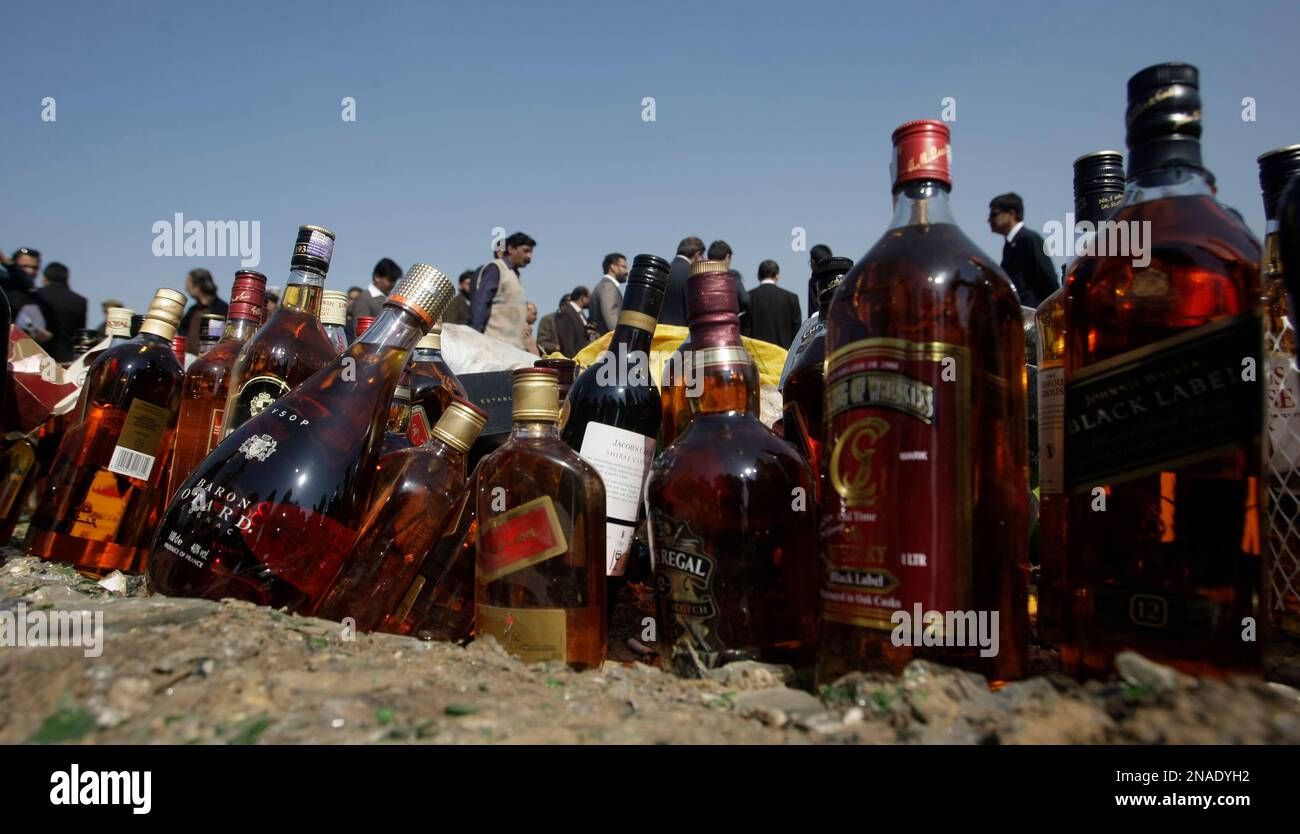 Pakistani customs personnel pile up the confiscated liquor to destroy ...