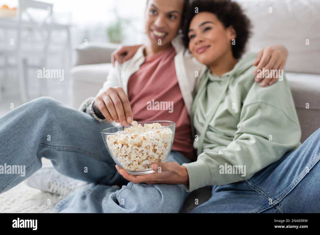 Blurred african american couple with popcorn hugging at home Stock ...