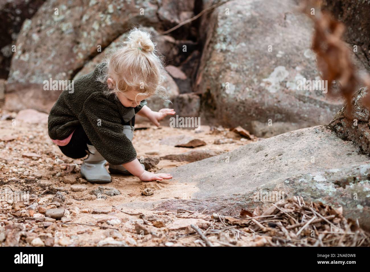 Child playing in sand along rocky river Stock Photo - Alamy