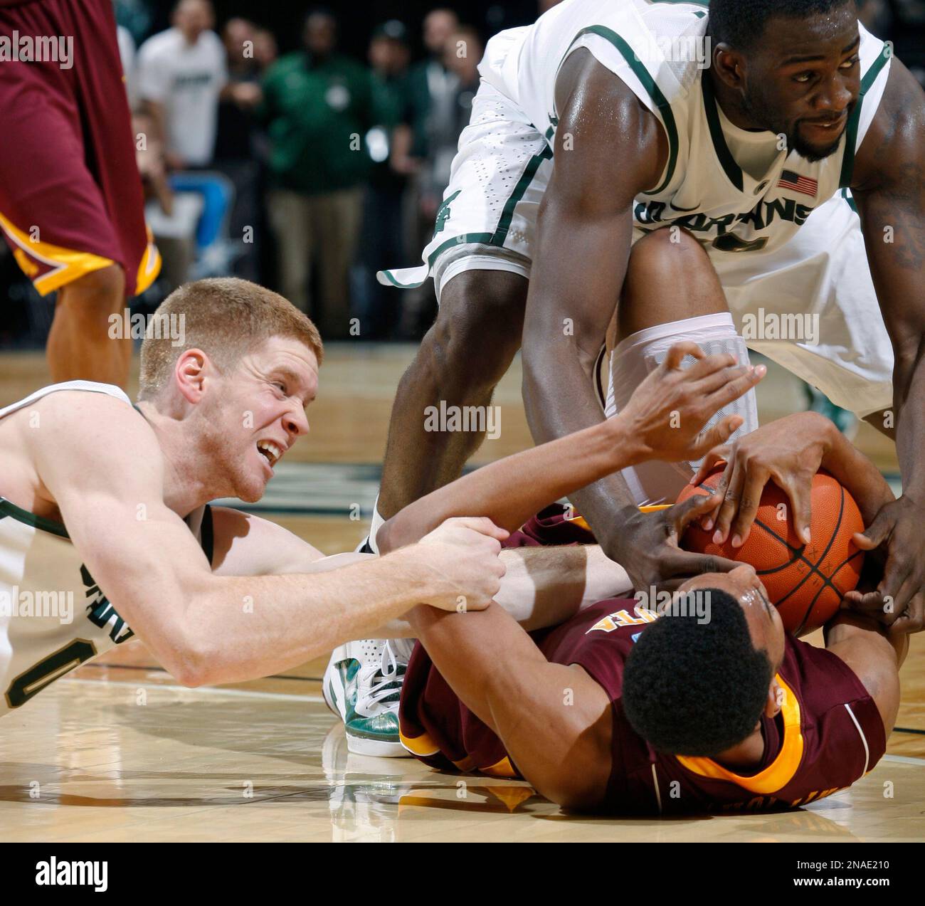 Michigan State's Russell Byrd, left, Minnesota's Andre Hollins, bottom ...