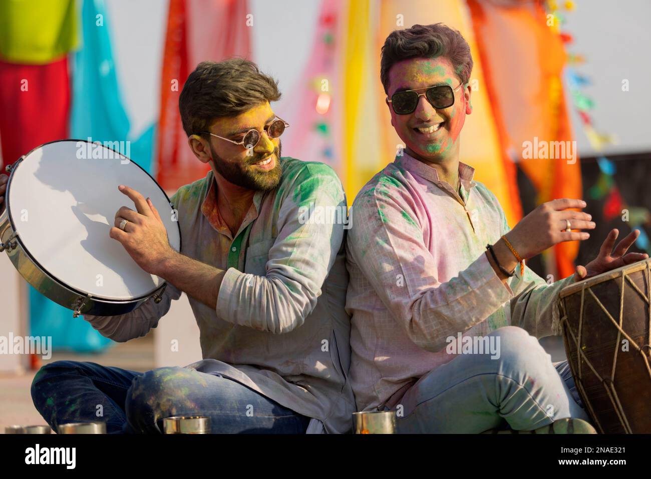 Two young indian men with colored face singing during holi color ...