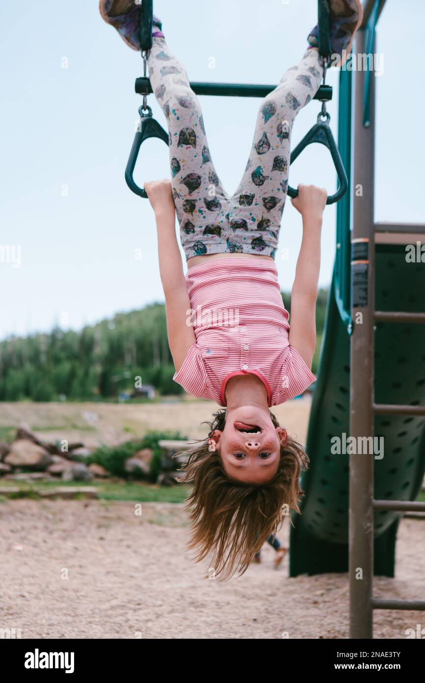 Silly kid plays on swing set at playground in summertime Stock Photo ...