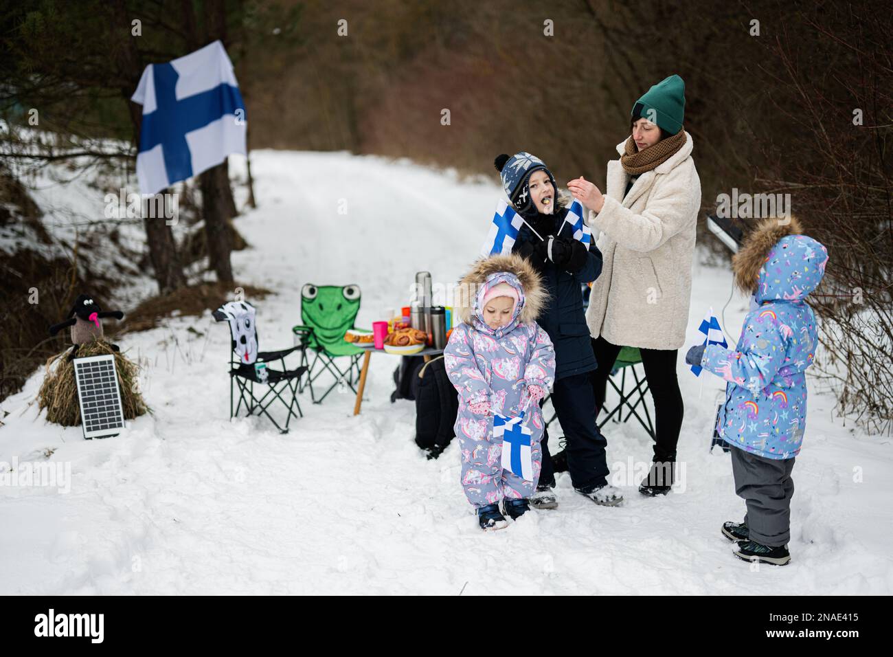 Finnish woman and kids with Finland flags on a nice winter day. Nordic ...
