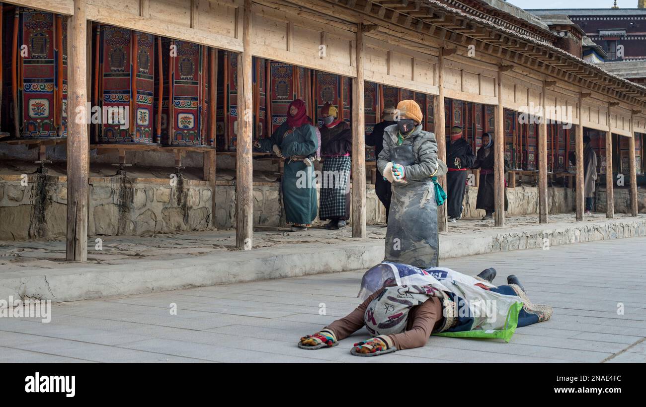 Buddhist pilgrims turning prayer wheels and prostrating; Labrang, Amdo ...